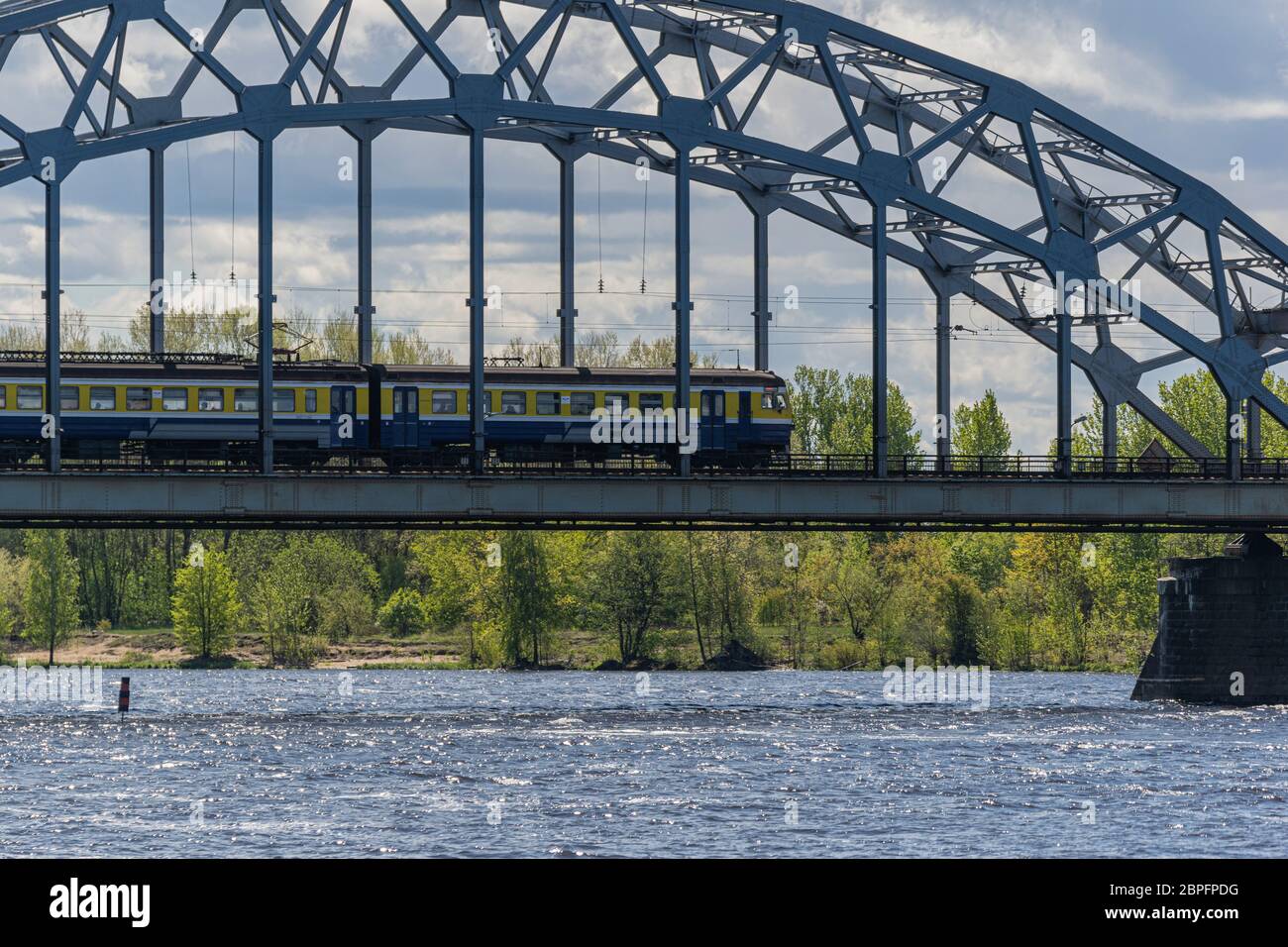Un train électrique traverse un pont qui traverse une rivière. Train de ...