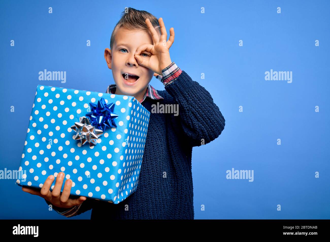 Jeune petit cacasien tenant boîte surprise comme cadeau d'anniversaire ...