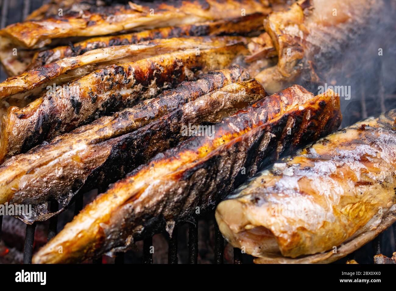 Poisson grillé avec fumée sur un barbecue au charbon de bois. Gros ...