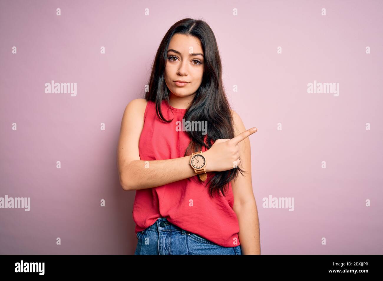 Jeune femme brune portant une chemise d'été décontractée sur fond rose ...