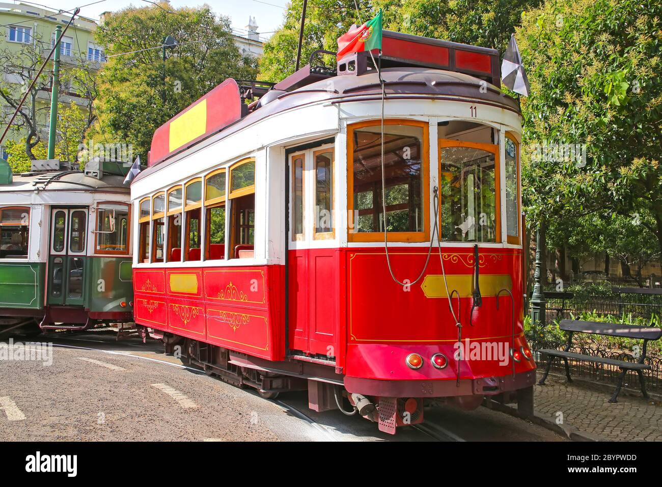 Tramway rouge historique contre les arbres, faisant partie du réseau de ...