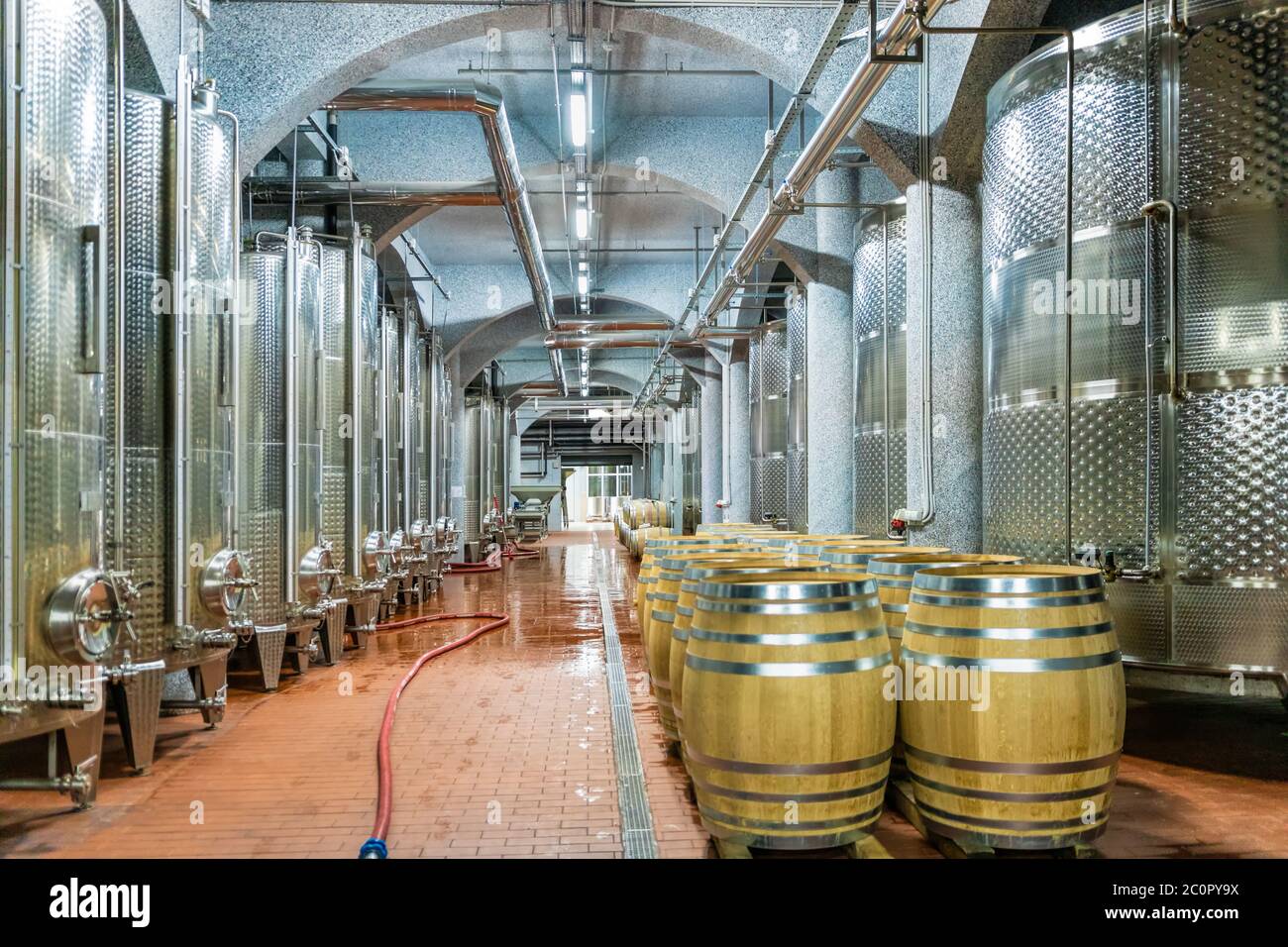 Rangée de grands fûts de vin rouge de chêne français dans un entrepôt ...