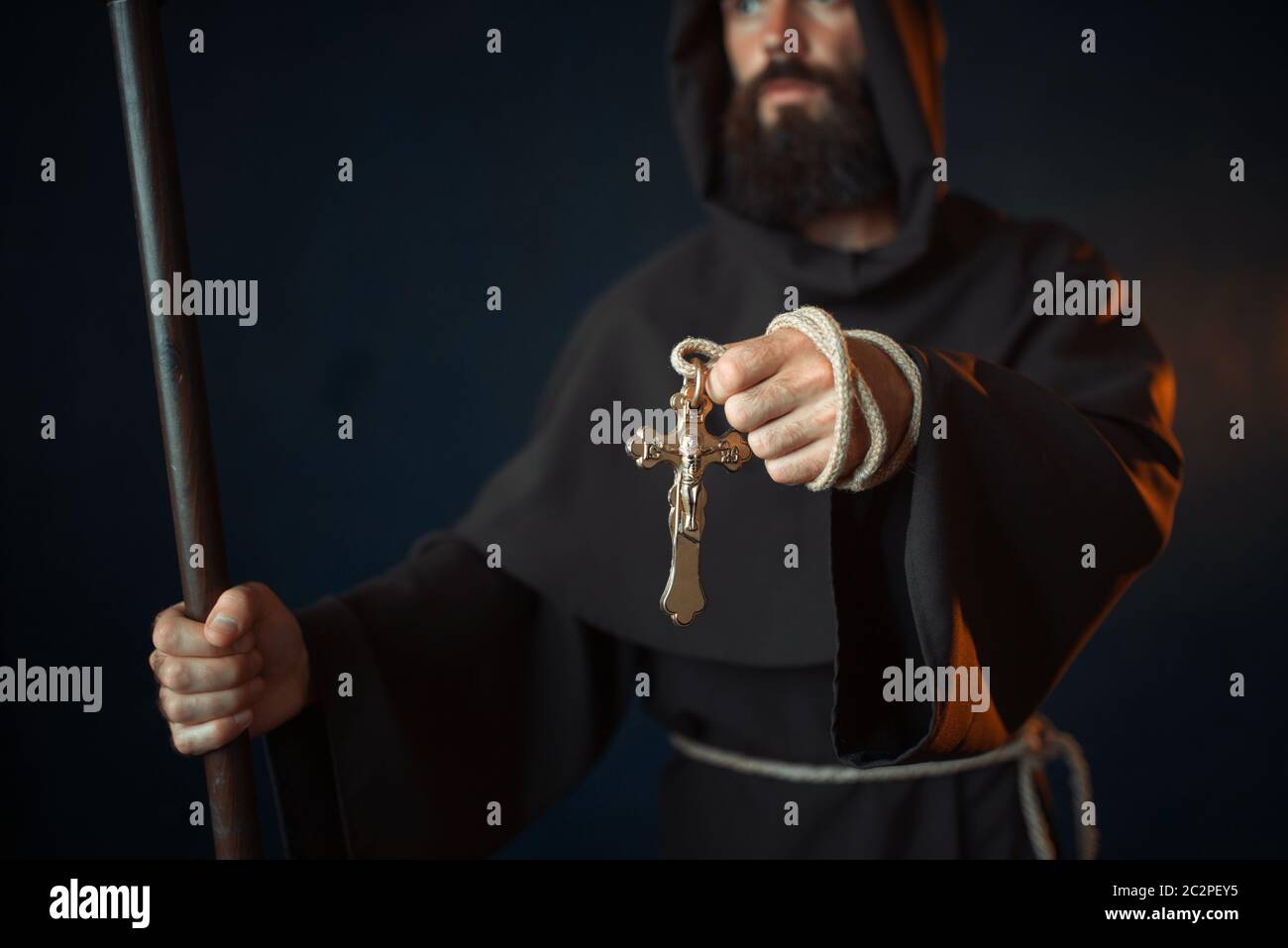 Moine médiéval avec bâton en bois et croix dans les mains, la religion ...