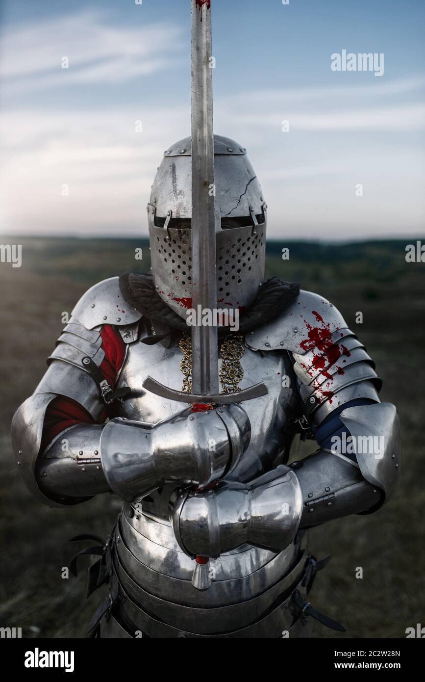 Chevalier médiéval en armure et casque pose avec épée, grande bataille ...