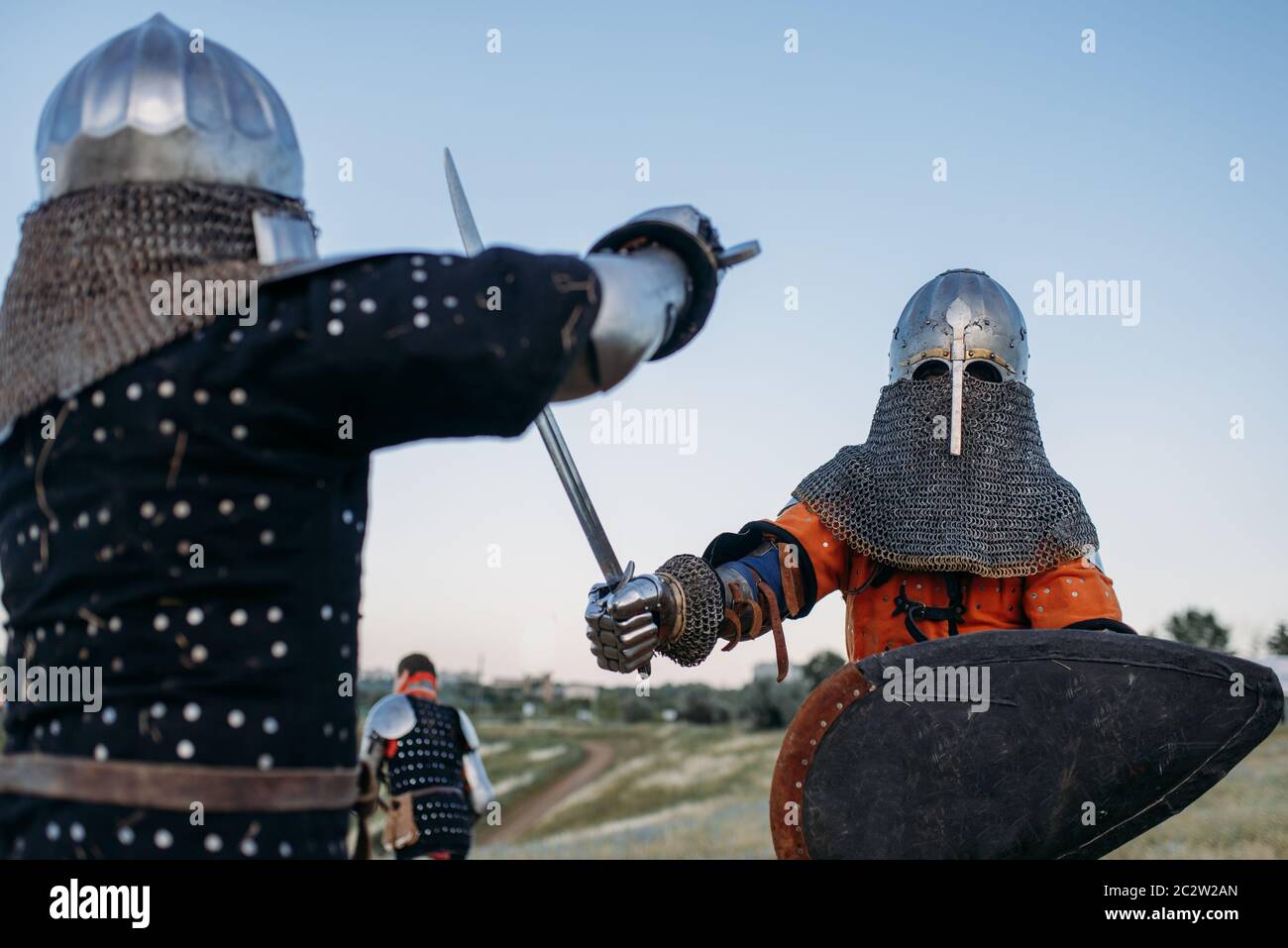 Les chevaliers médiévaux en armure et casques se battent avec des épées ...