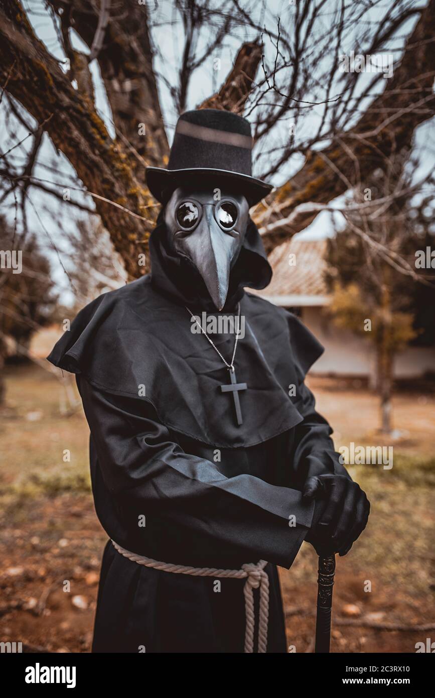 Médecin de la peste avec une canne et une garbe sombre classique avec ...