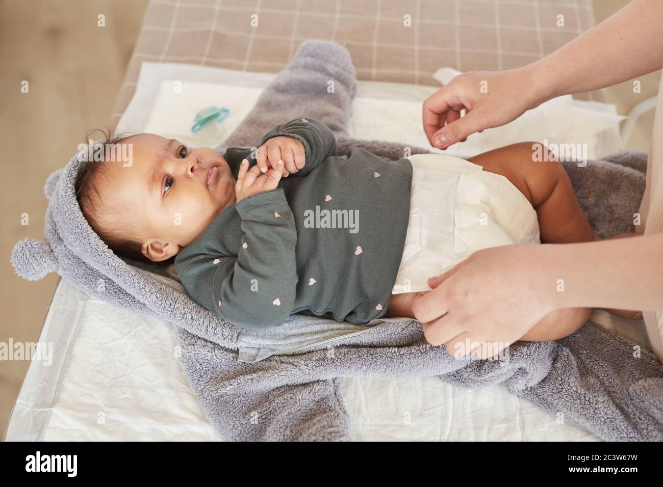 Portrait ton chaud de mère méconnaissable déguissant un bébé mixte ...