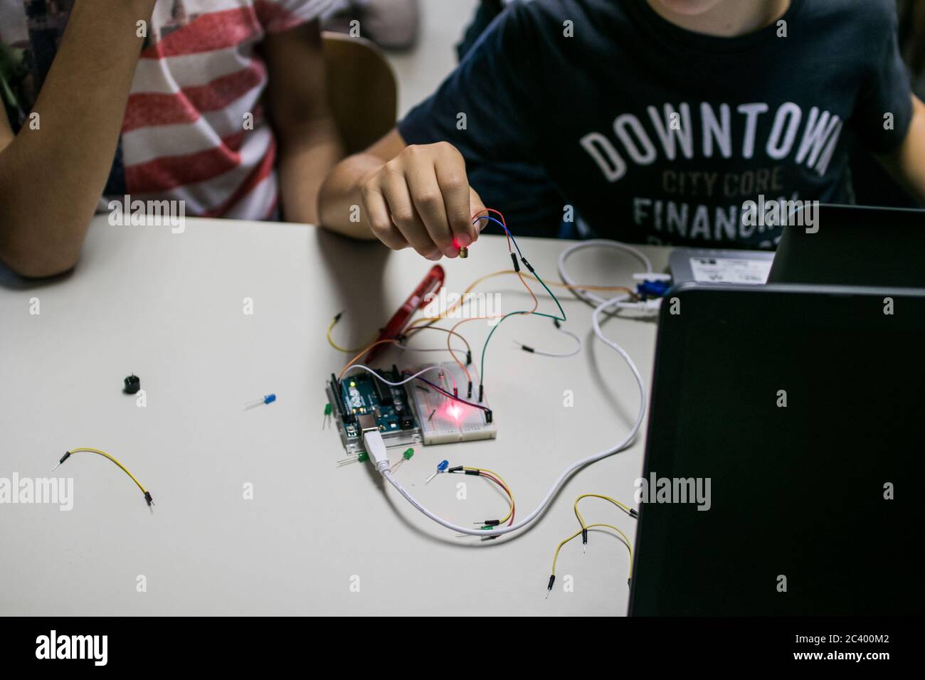 deux enfants construisent un circuit prototype avec un laser rouge ...