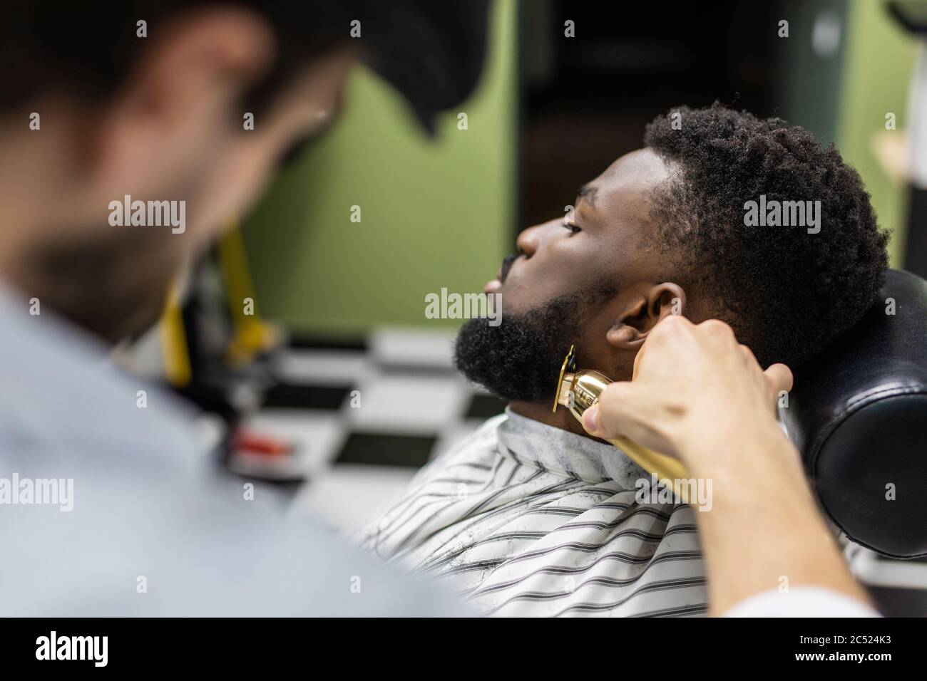 Coiffeur tondeuse cheveux sur jeune homme noir non rasé en atelier de ...