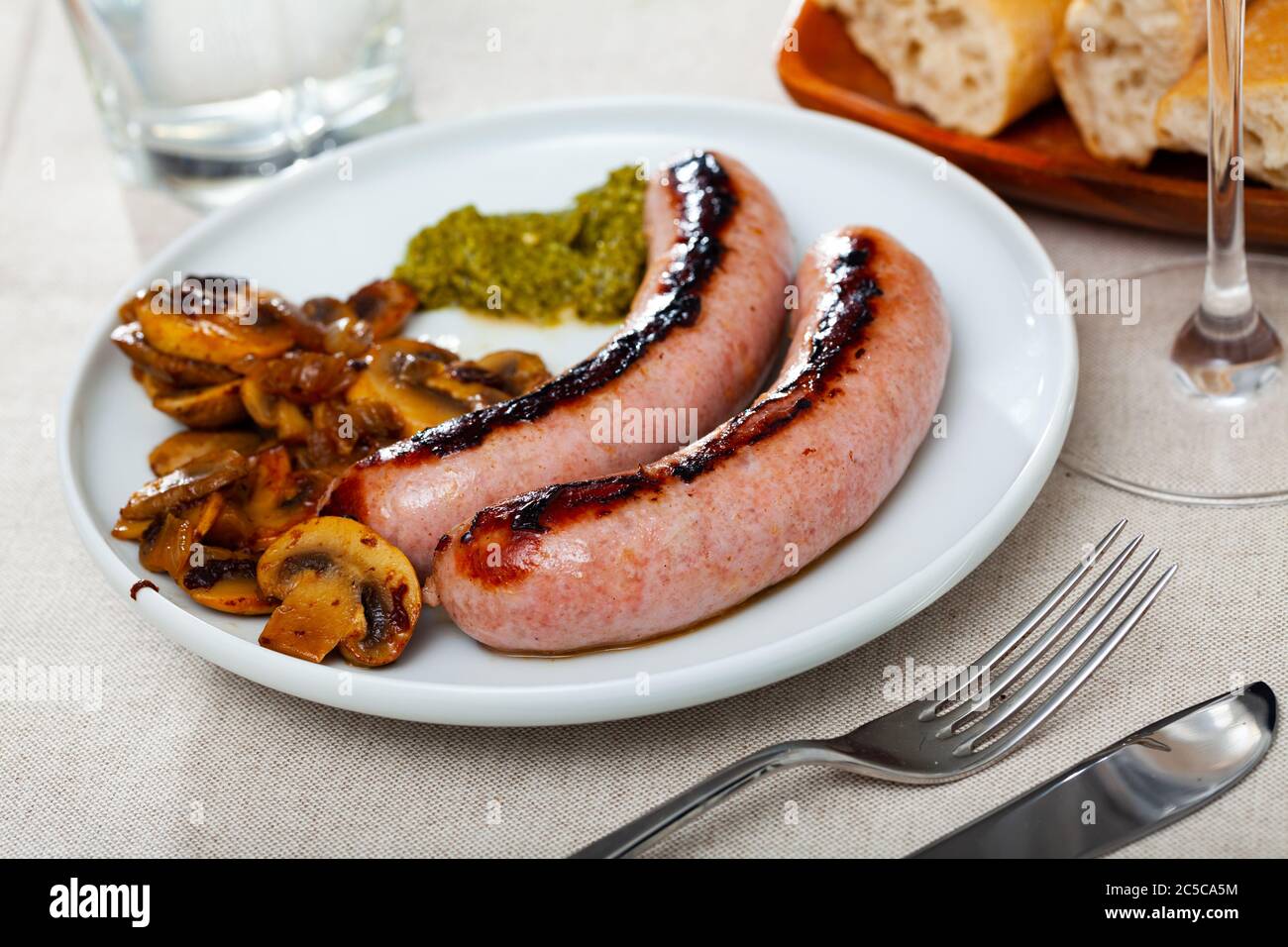 Image de saucisses savoureuses à la viande servies avec des champignons de Paris Photo Stock - Alamy