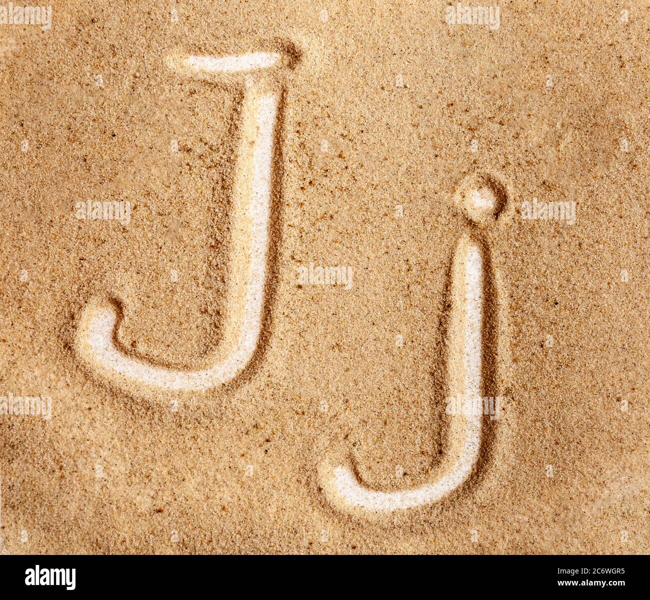 Lettre J. anglais manuscrit Alphabet dans le sable Photo Stock - Alamy