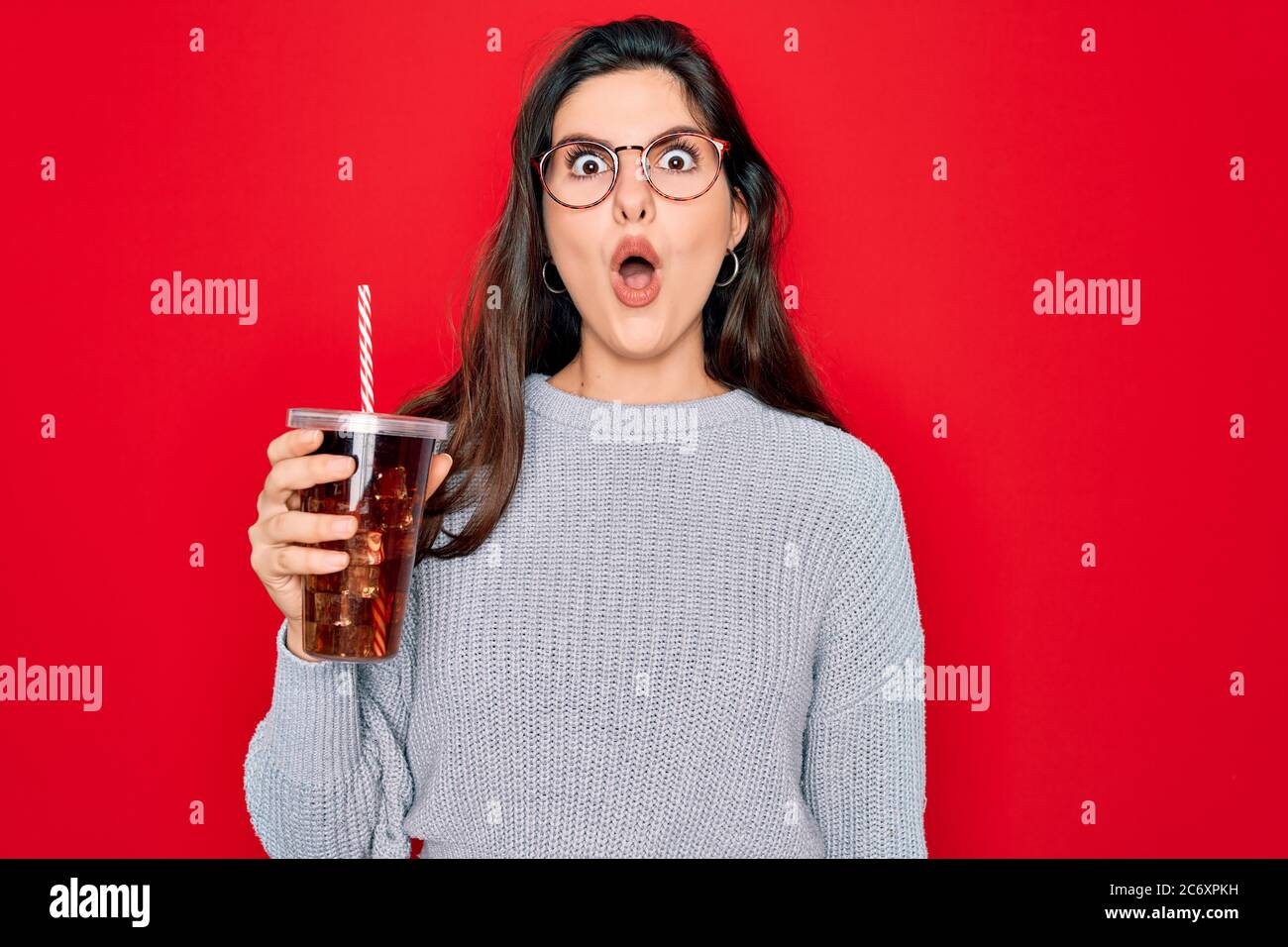 Jeune fille belle portant des lunettes boisson sucrée soda sur fond ...