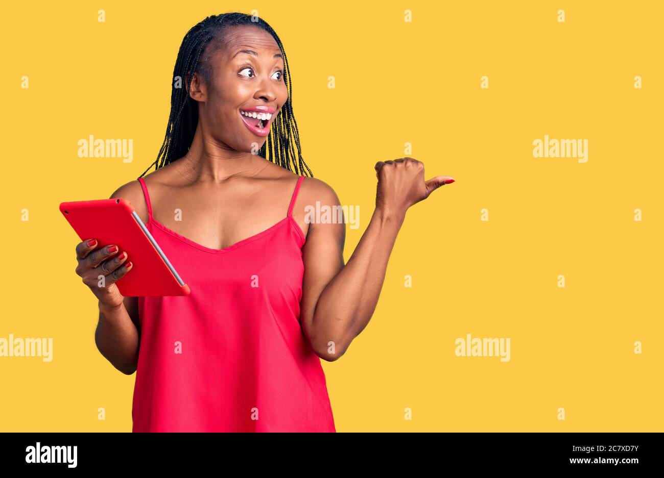 Jeune femme afro-américaine tenant le pavé tactile pointant le pouce ...