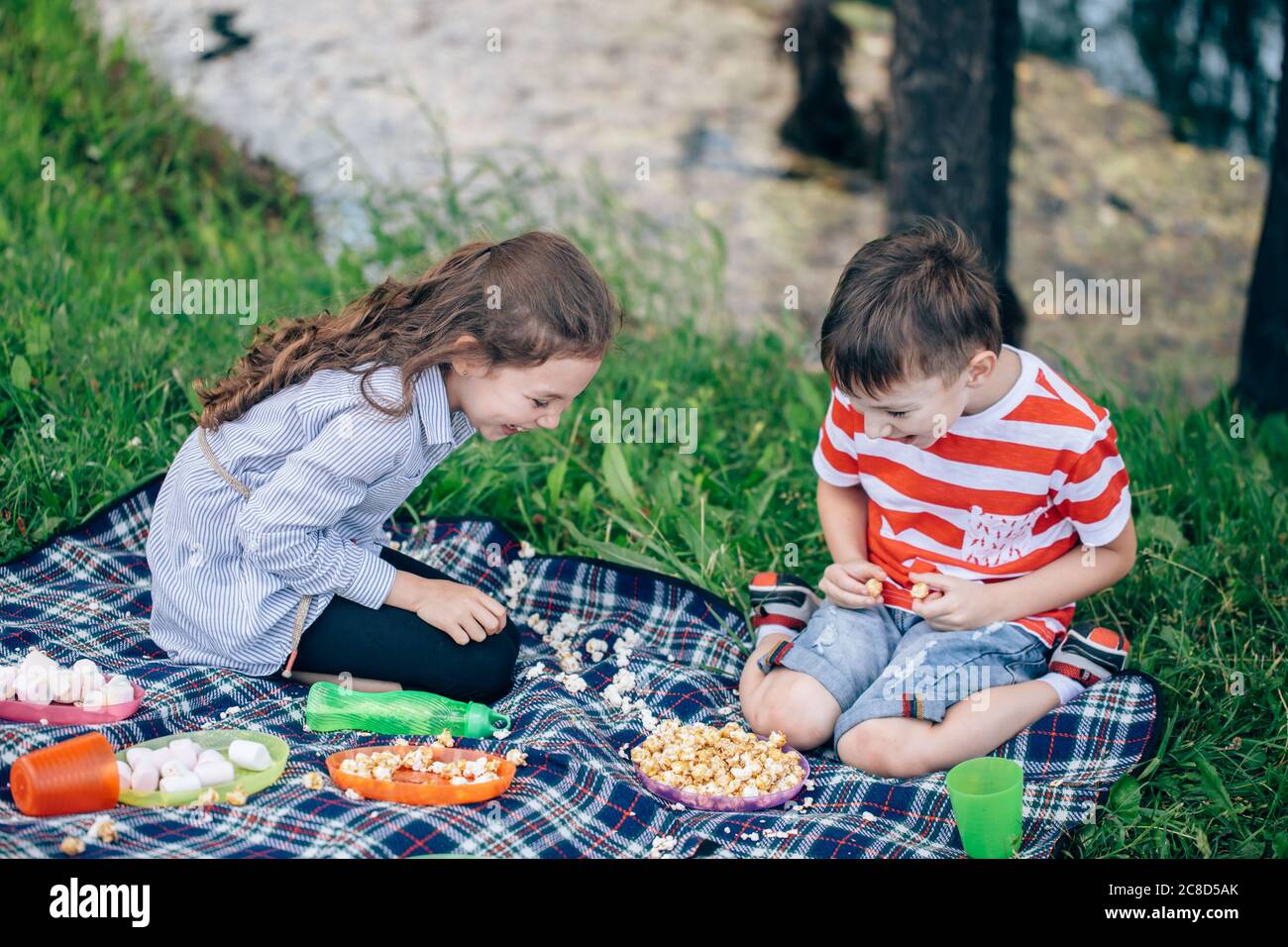 Portrait de trois enfants s'amuser dans le jardin en été. Ils rient en ...