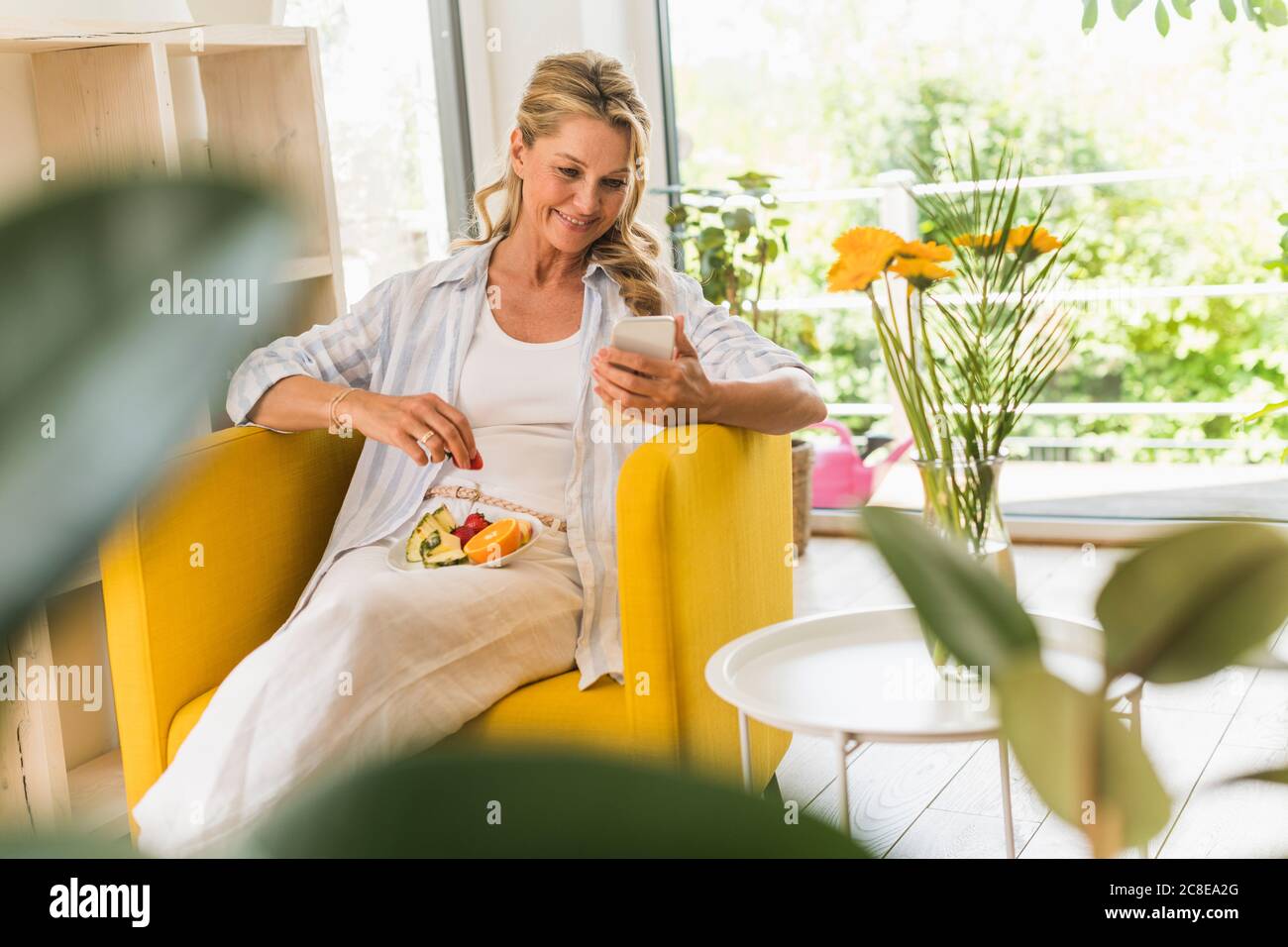 Femme mature assise dans un fauteuil Banque de photographies et d’images à haute résolution - Alamy