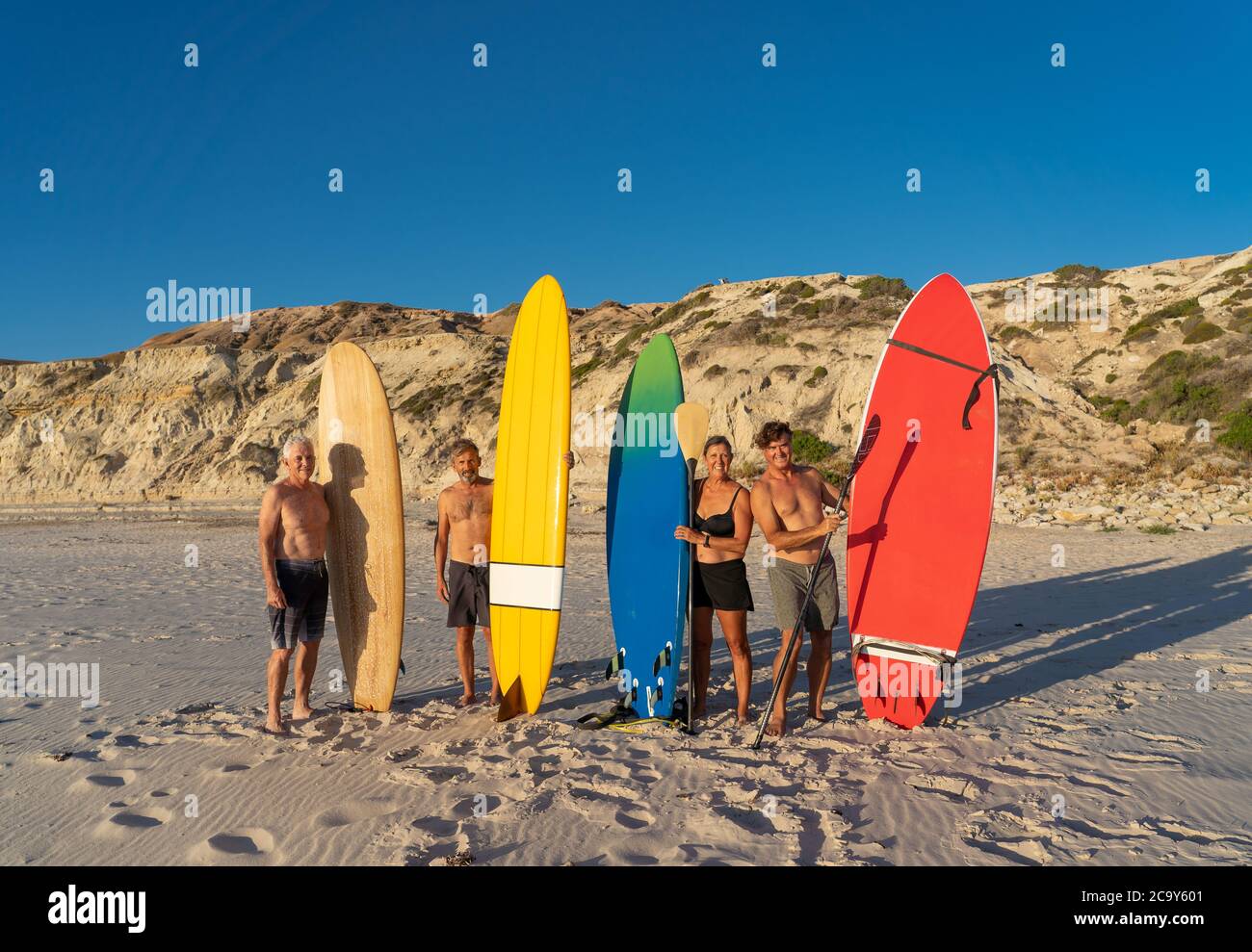 Groupe de surfeurs âgés, femme et homme, tenant leurs planches de surf ...