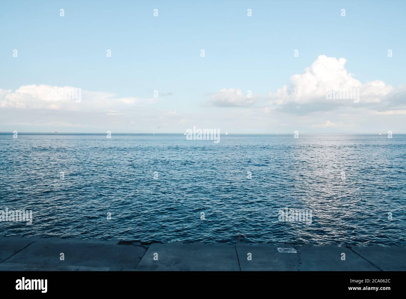 Mer calme avec un bateau au loin et plage Banque de photographies et d ...