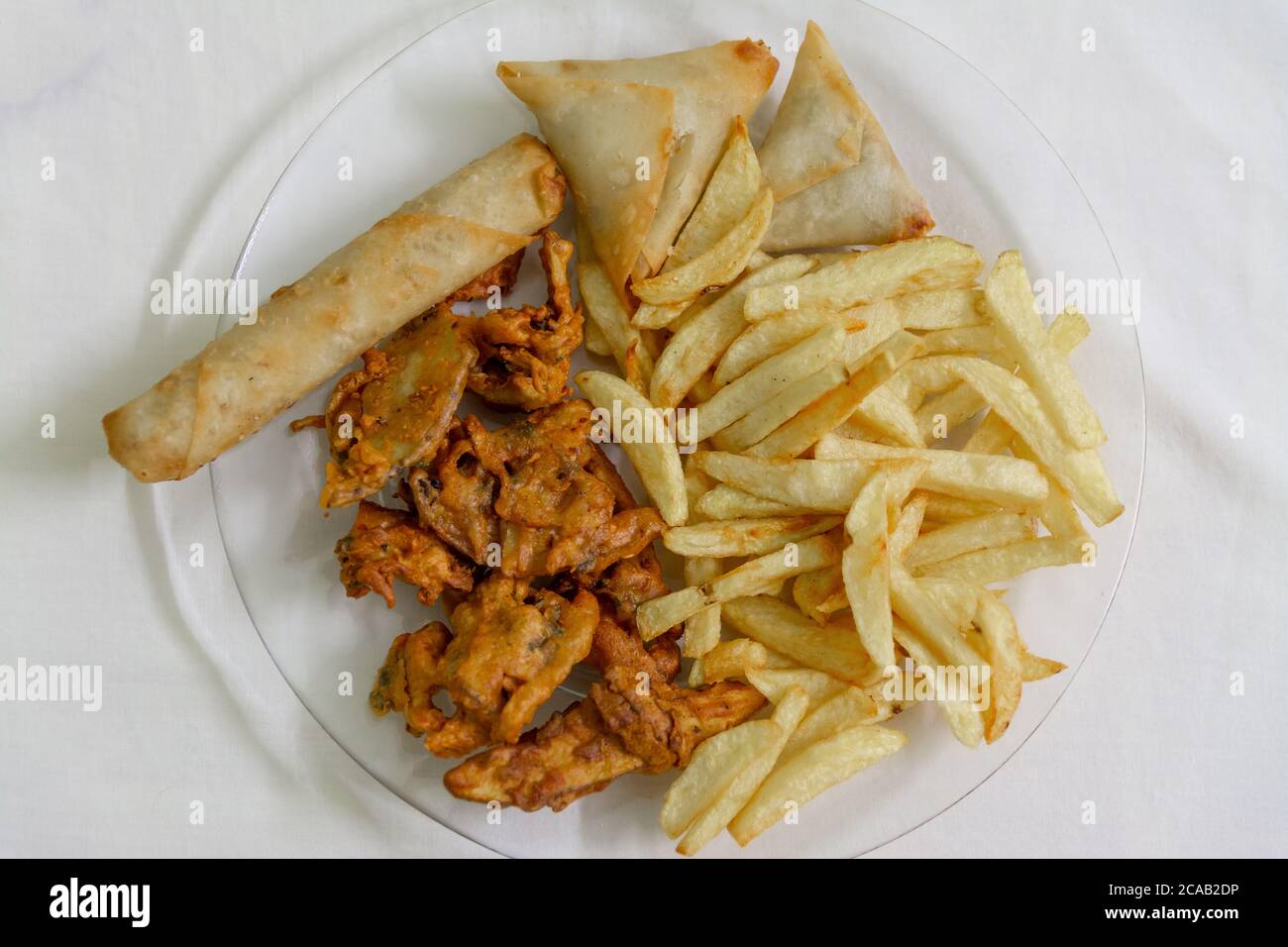 Gros plan des frites et autres aliments frits sur un surface blanche ...