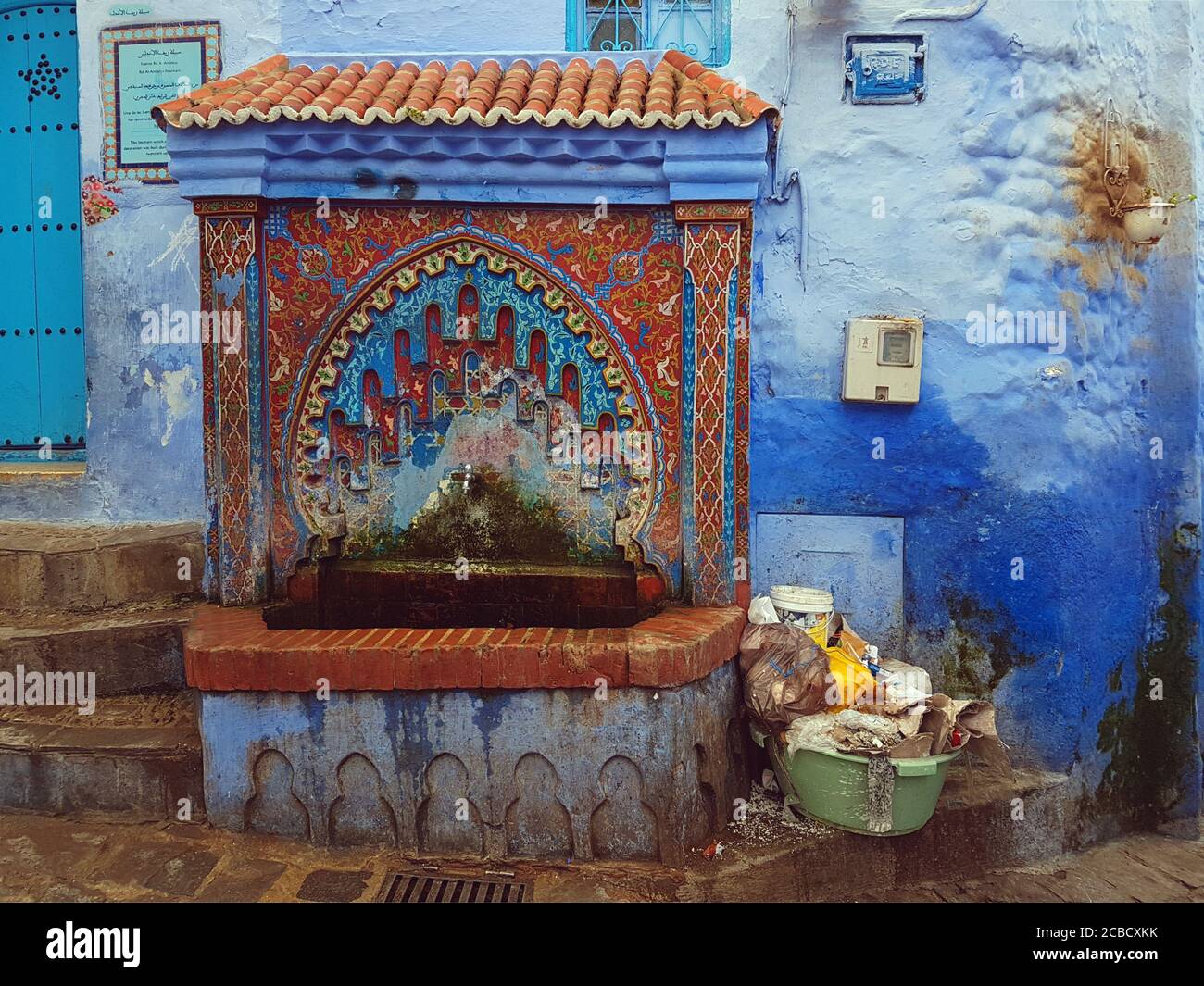 L'eau de la rue antique avec un mur bordé de mosaïques rouges, à côté d ...