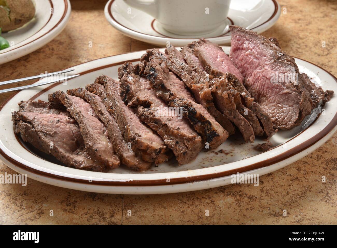 Tranches fines de boeuf saignante rôti sur un plat de service Photo ...