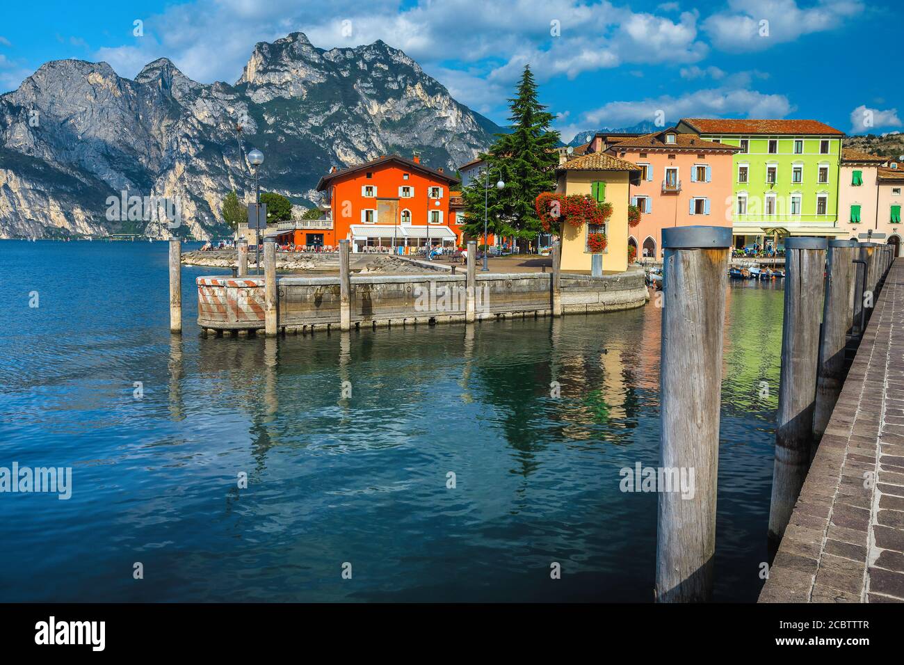Bâtiments colorés sur la rive du lac de Garde. Petit port avec bateaux ...