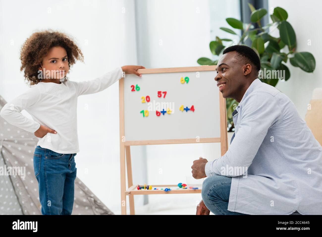 Père Afro Américain Regardant Une Fille Sérieuse Debout Avec La Main