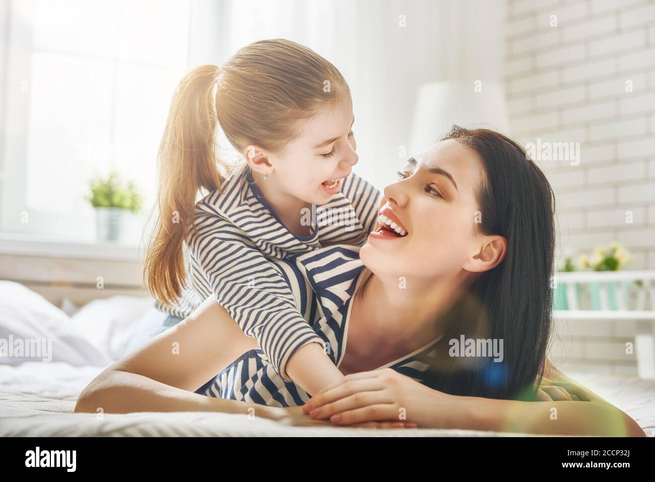 Bonne fête des mères ! Maman et sa fille fille fille fille jouent, sourient et embrasent ...