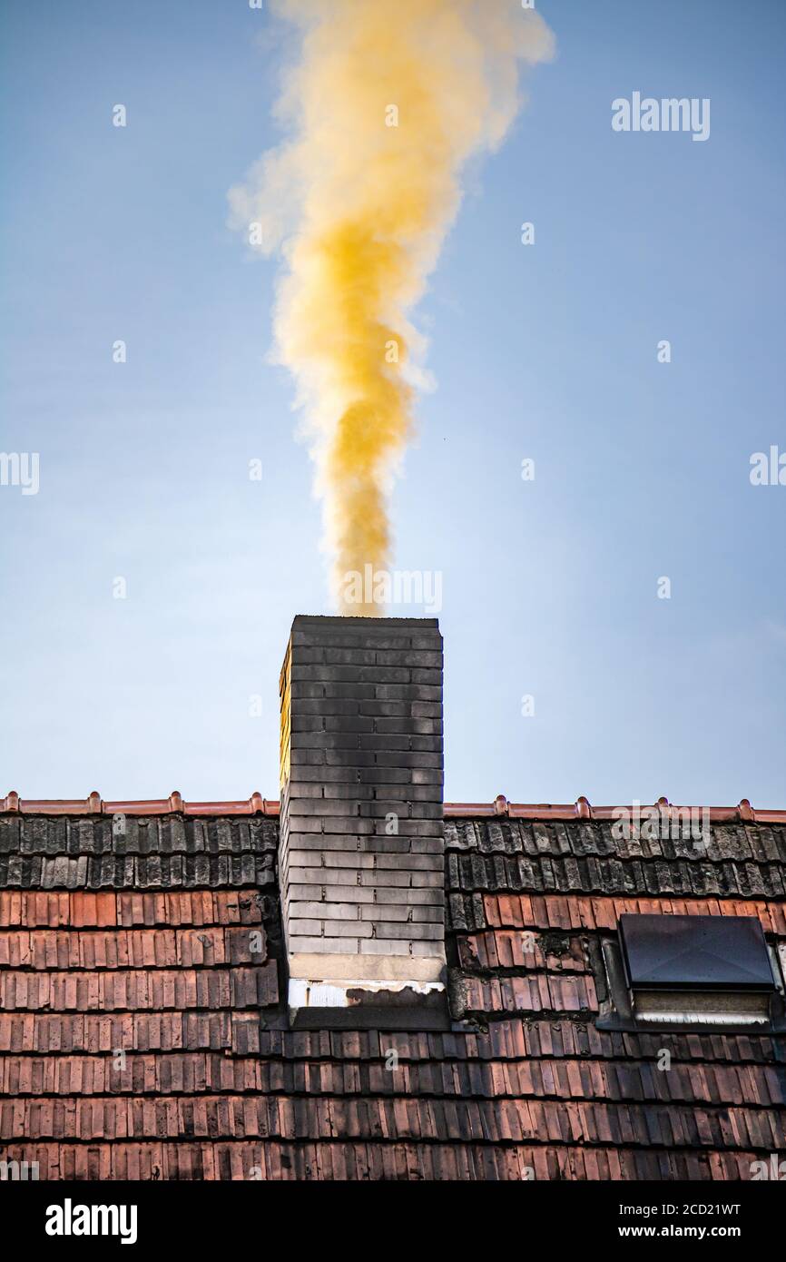 Une épaisse fumée jaune s'élève au ciel bleu de la cheminée de la ...