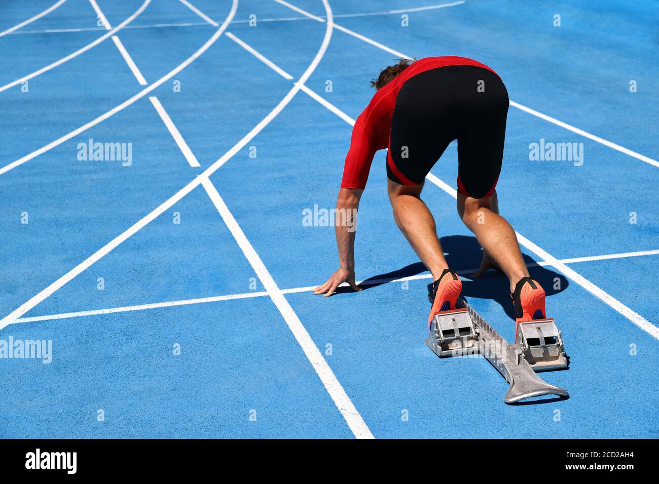 Coureur prêt à courir sur la ligne de départ de piste de course ...