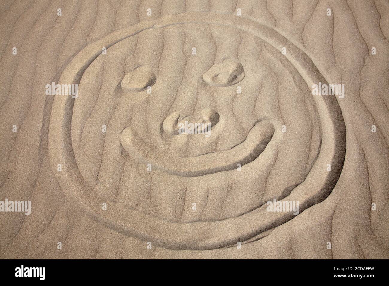 Smiley visage texture arrière-plan dessin sur une plage de sable de ...