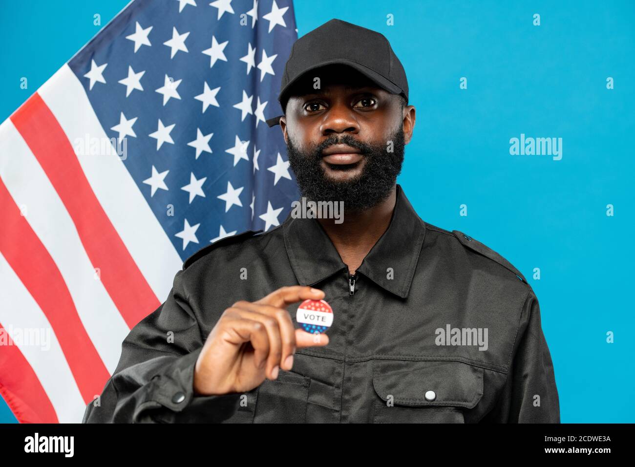 Un jeune homme de sécurité afro-américain barbu en uniforme montre son ...