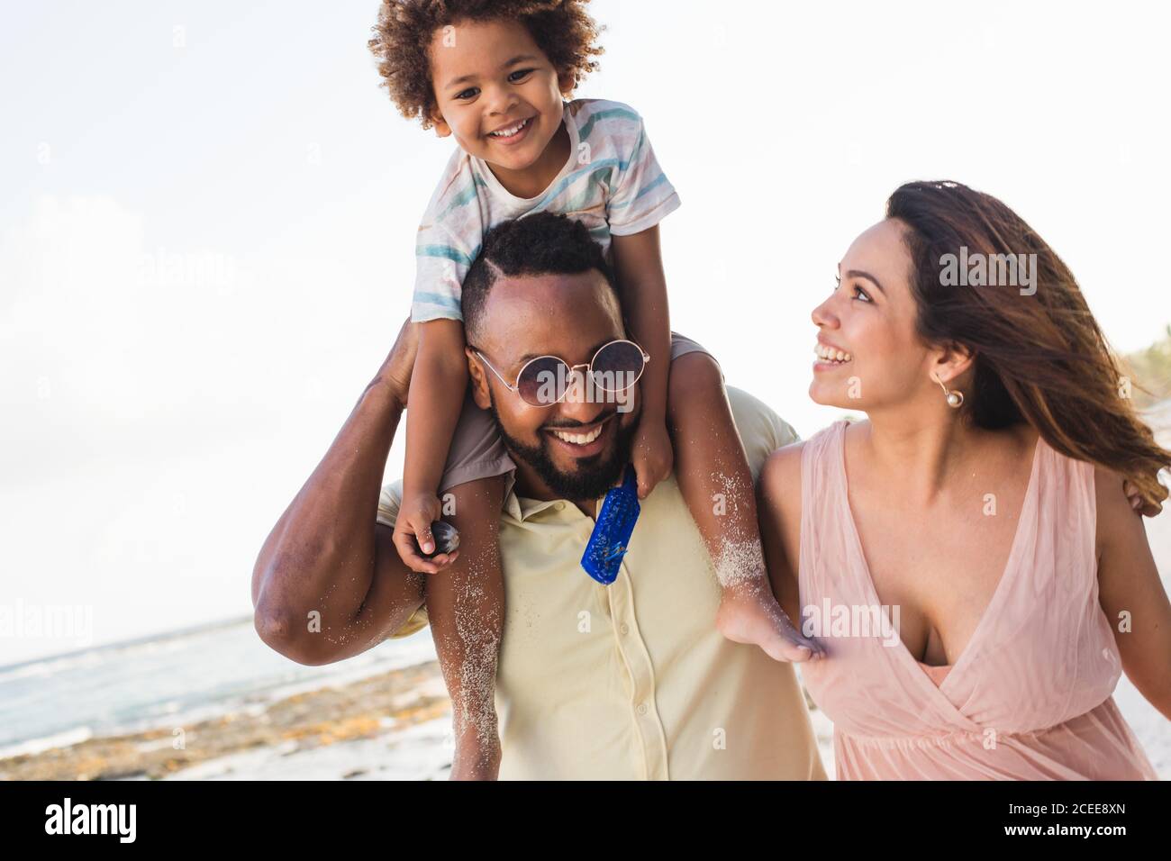 Femme Portant Son Fils Sur Le Dos Et Souriant Banque De Photographies