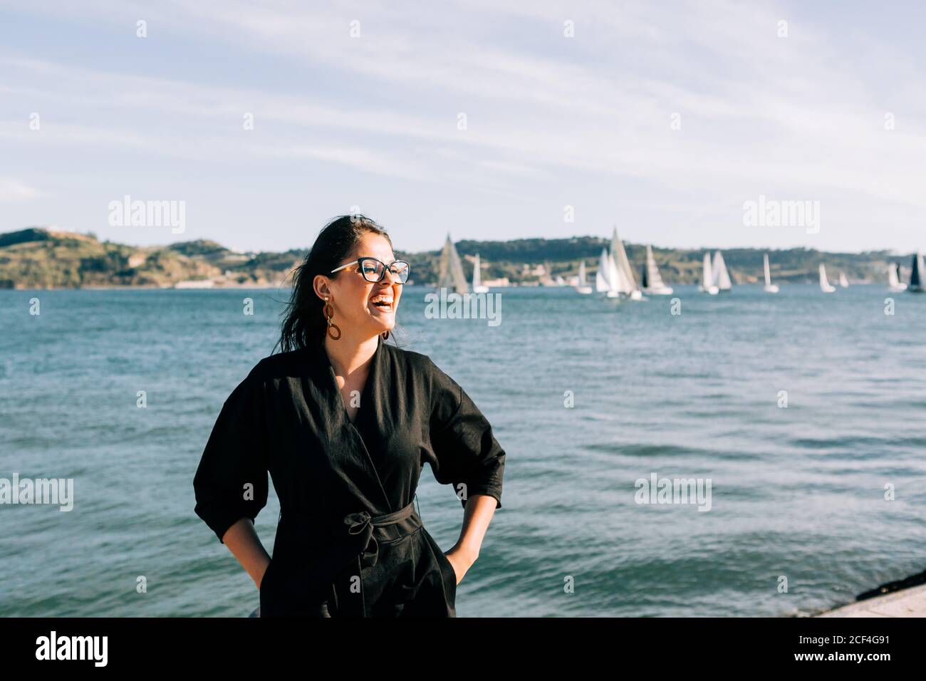Vue latérale d'une jeune femme attirante vêtue de noir debout près de ...