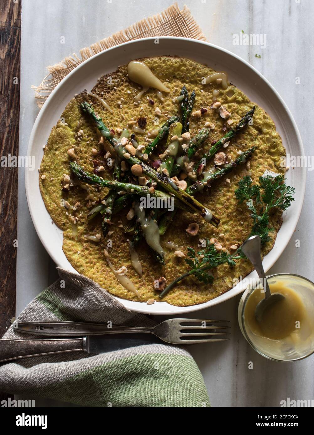 Vue de dessus d'une assiette blanche avec crêpe d'avoine et asperges et ...
