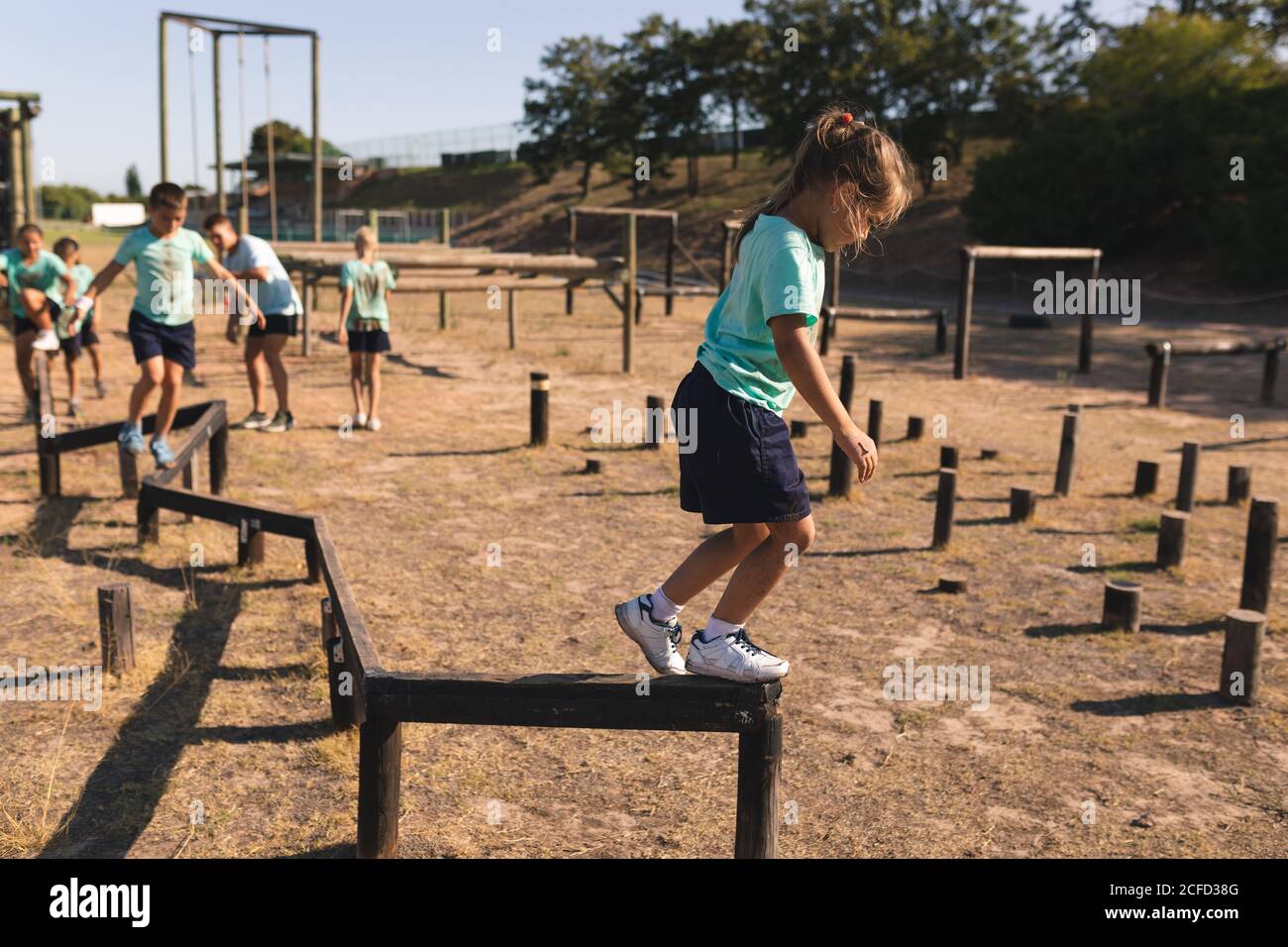 Groupe d'enfants marchant à travers un parcours d'obstacles à un camp d ...