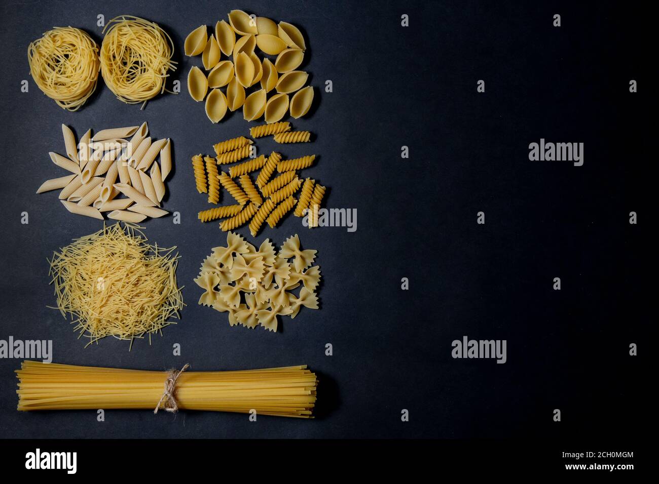 Différents types de pâtes sur fond noir. Vue d'en haut. Diverses formes ...