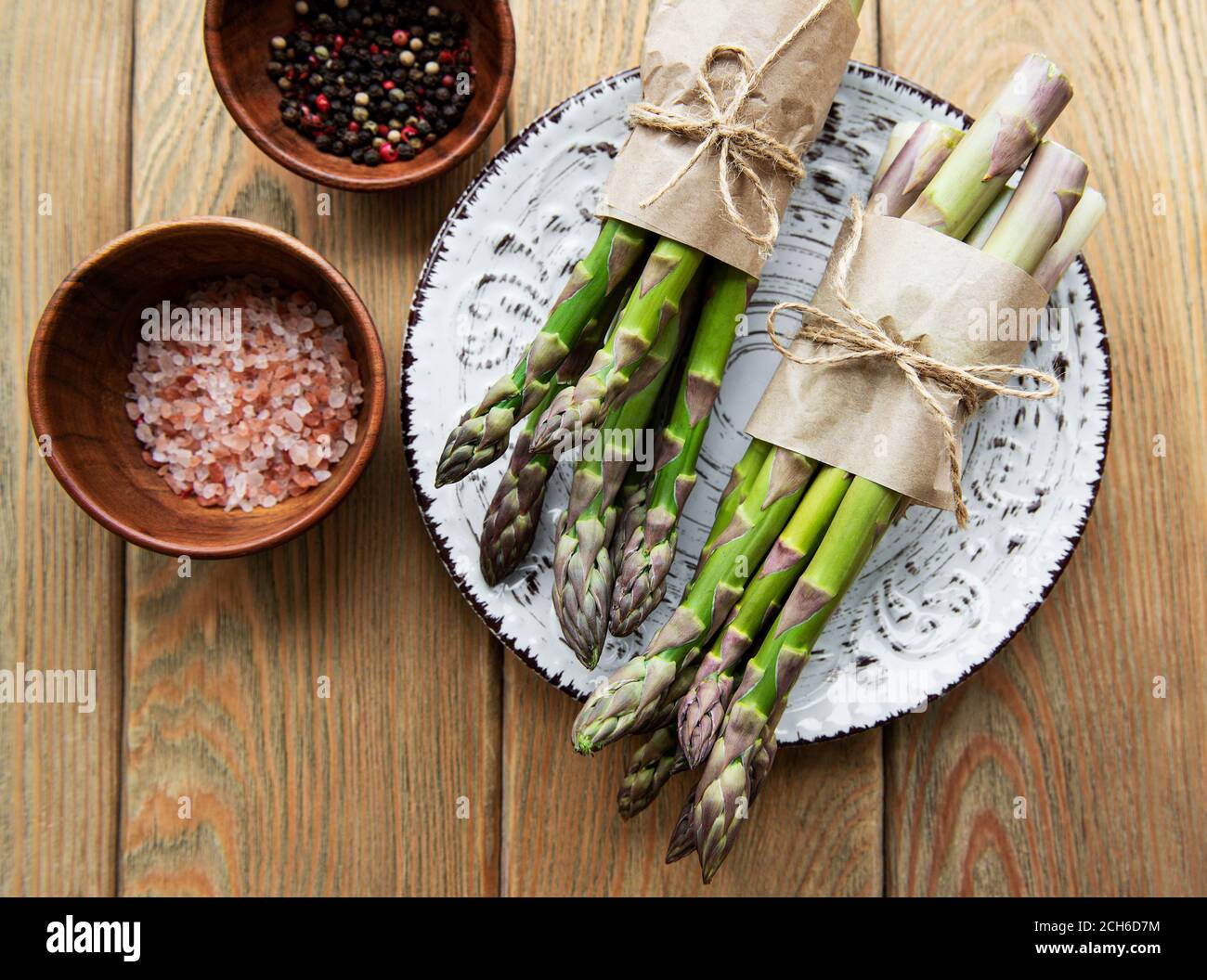 Assiette avec asperges vertes fraîches sur une ancienne table en bois ...
