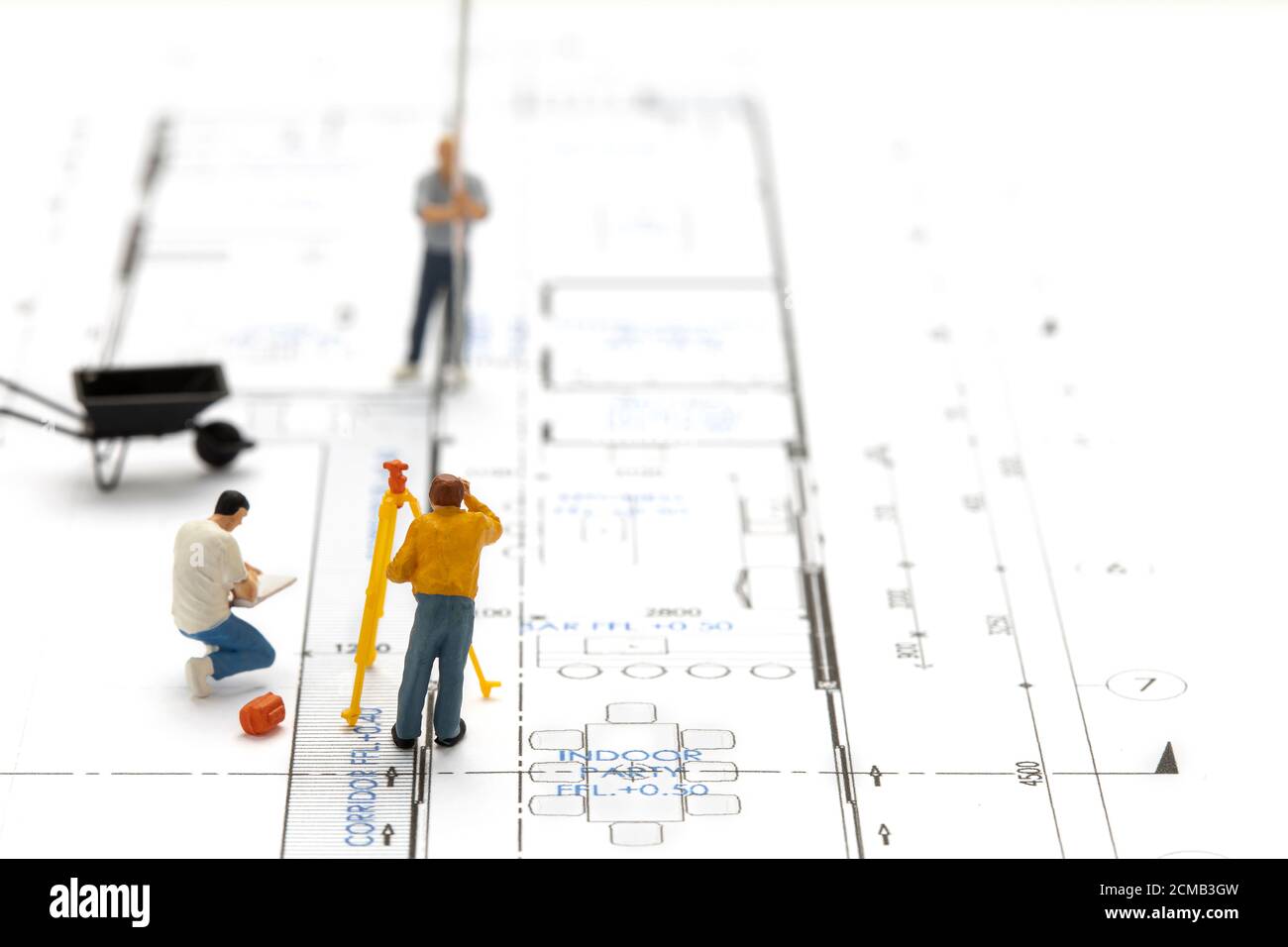 Le technicien d'arpenteur de personnes miniatures mesure la distance ...
