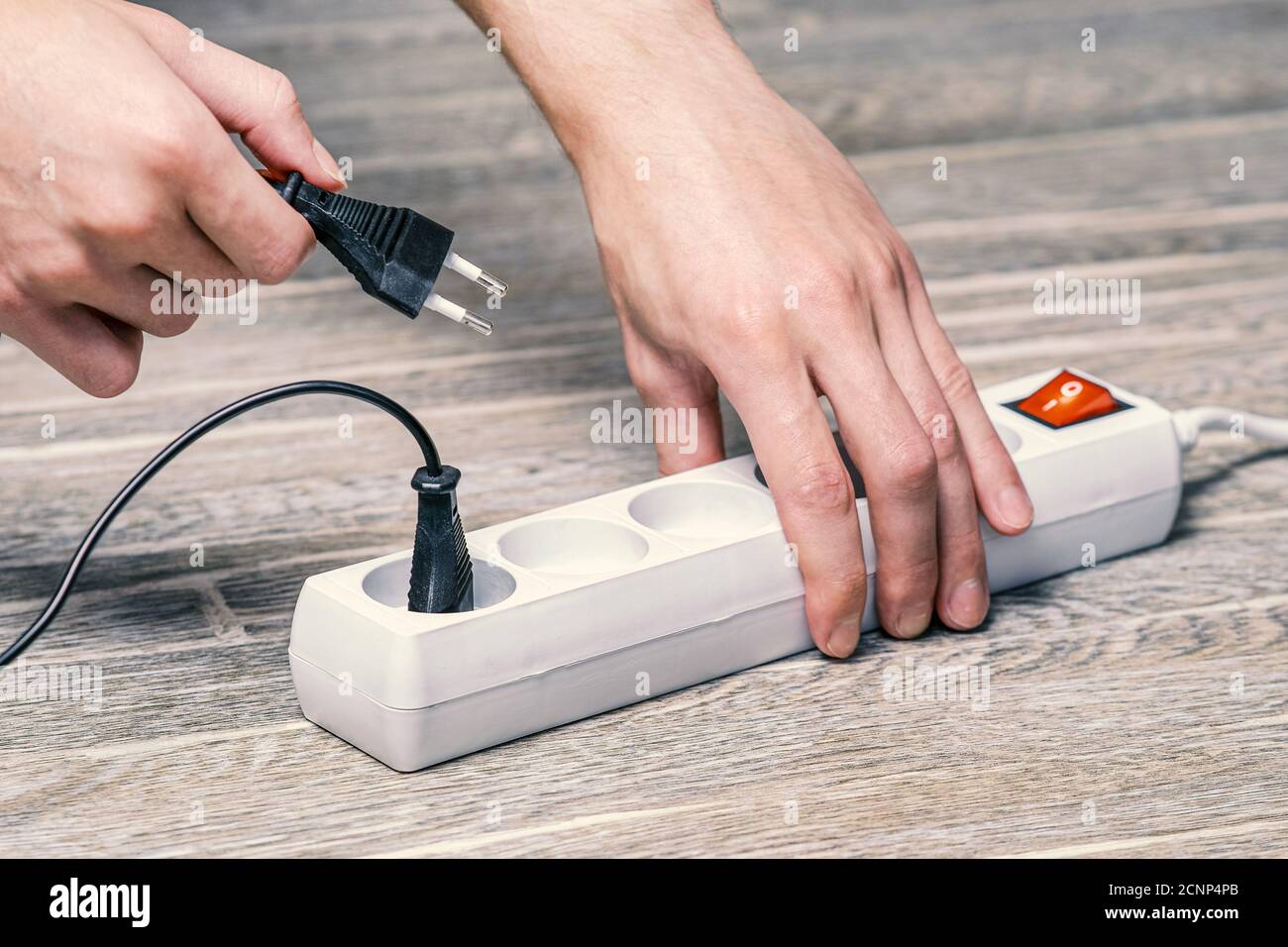 L'hôtesse tient dans sa main une rallonge électrique à l'aide d'un ...