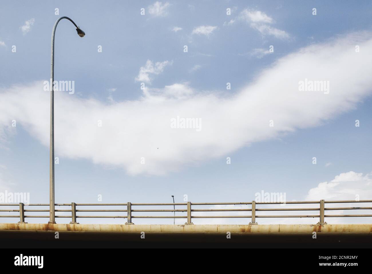 Un feu de rue tournant au-dessus d'un pont d'autoroute avec un rail de ...