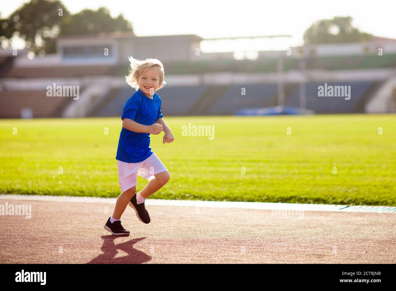 Enfant en train de courir dans le stade. Les enfants courent sur une ...