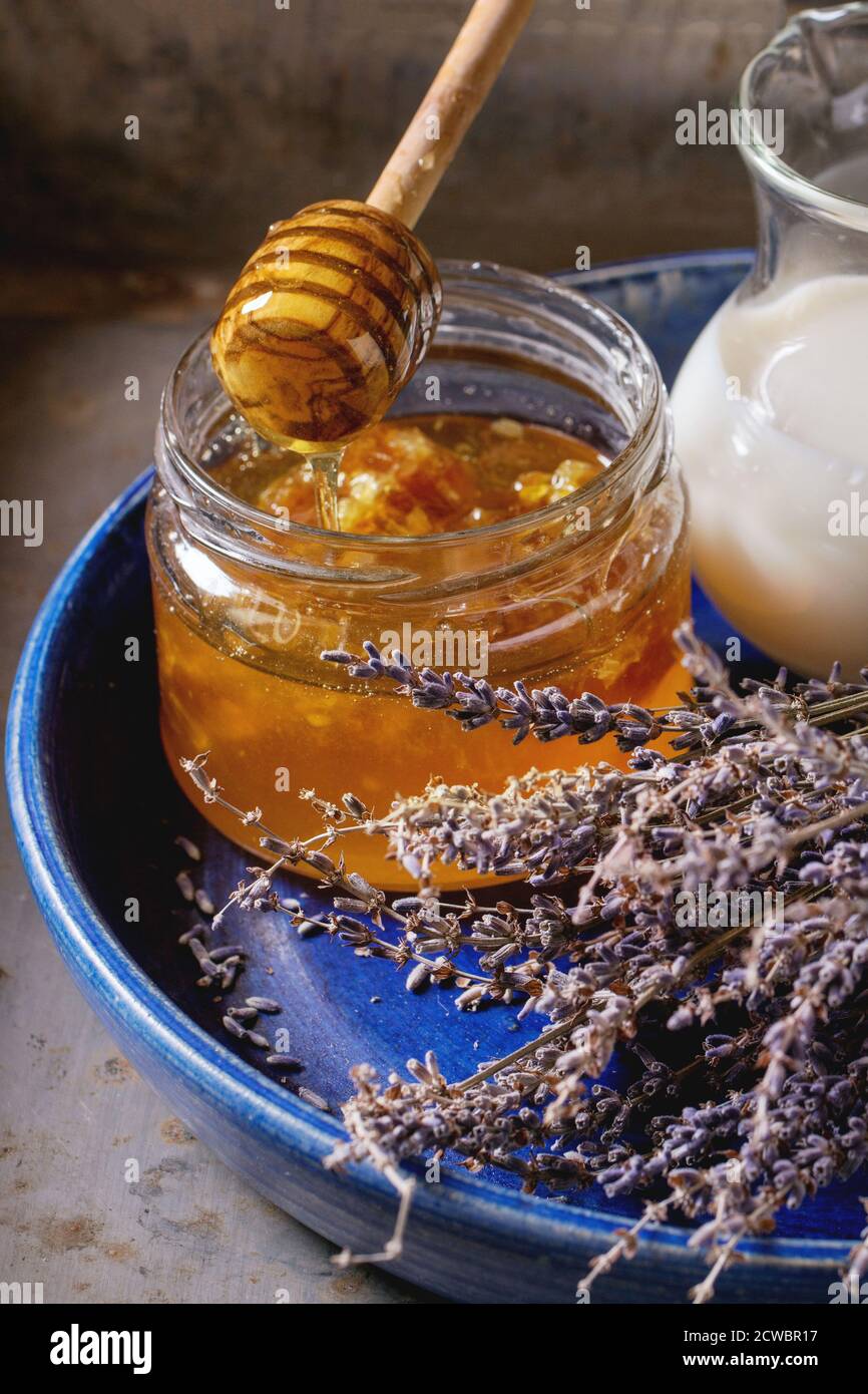 Ouvrir un bocal en verre de miel liquide et le miel d'abeilles avec ...