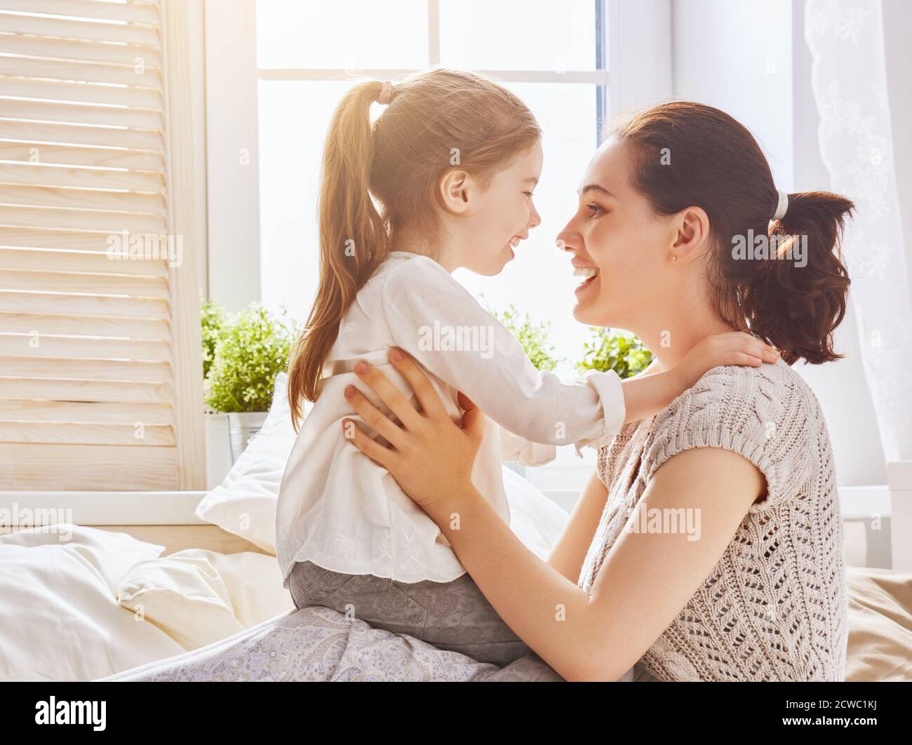 Bonne fête des mères ! Maman et sa fille fille fille fille jouent, sourient et embrasent ...