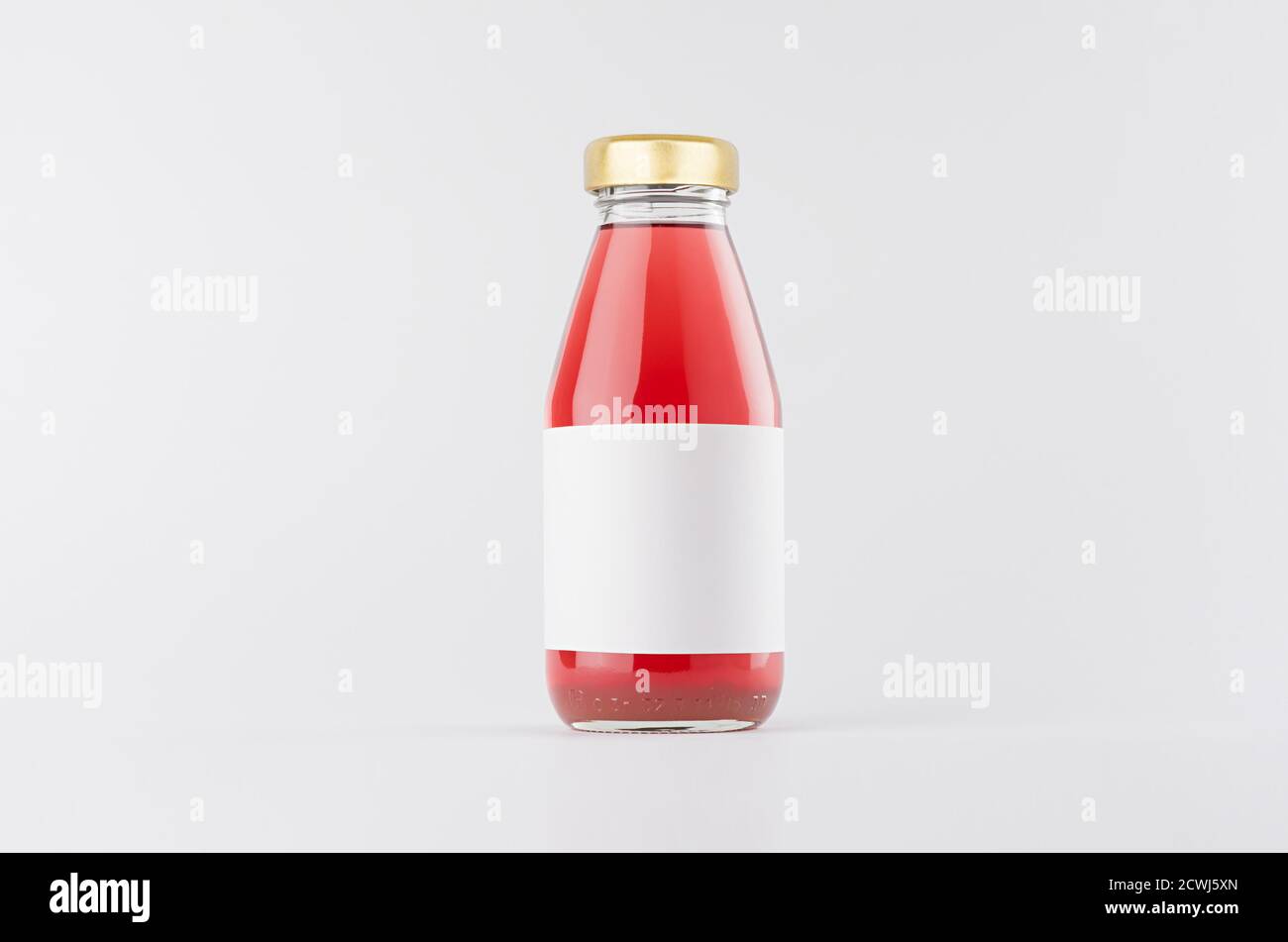 Jus de fraise rose en bouteille de verre avec bouchon doré et étiquette ...