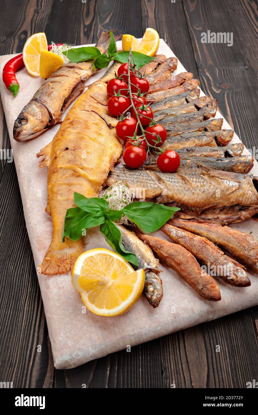 Assortiment de poissons frits sur une table en bois sombre Photo Stock ...