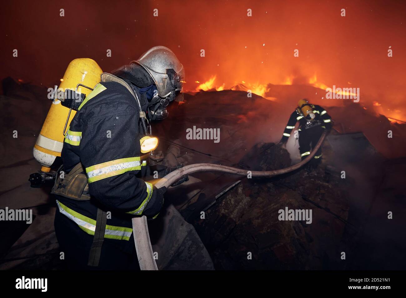 Équipe de pompiers lors de l'extinction d'un incendie important dans un ...
