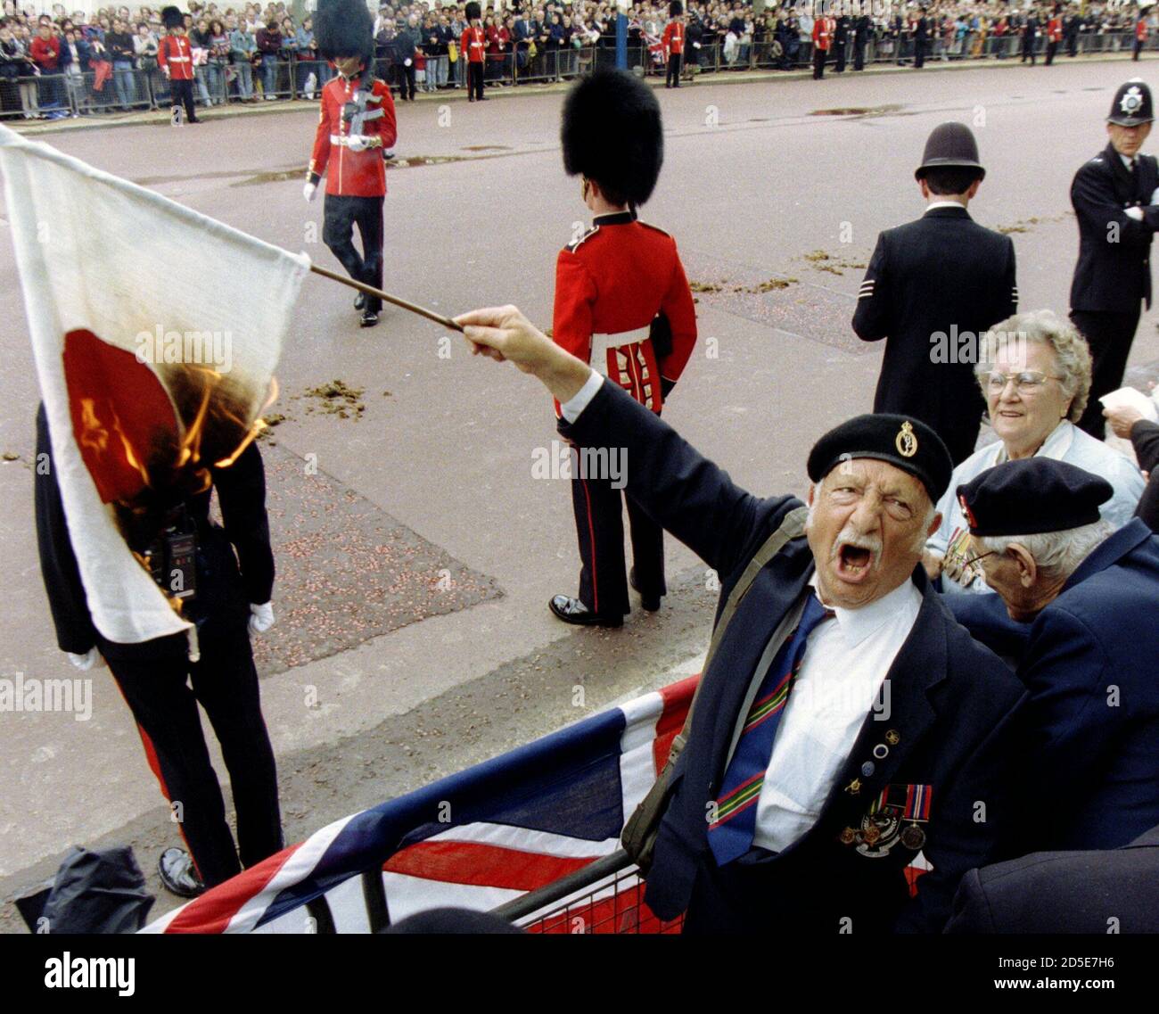 Former prisoner of war Jack Caplan, from Glasgow, burns a Japanese flag ...