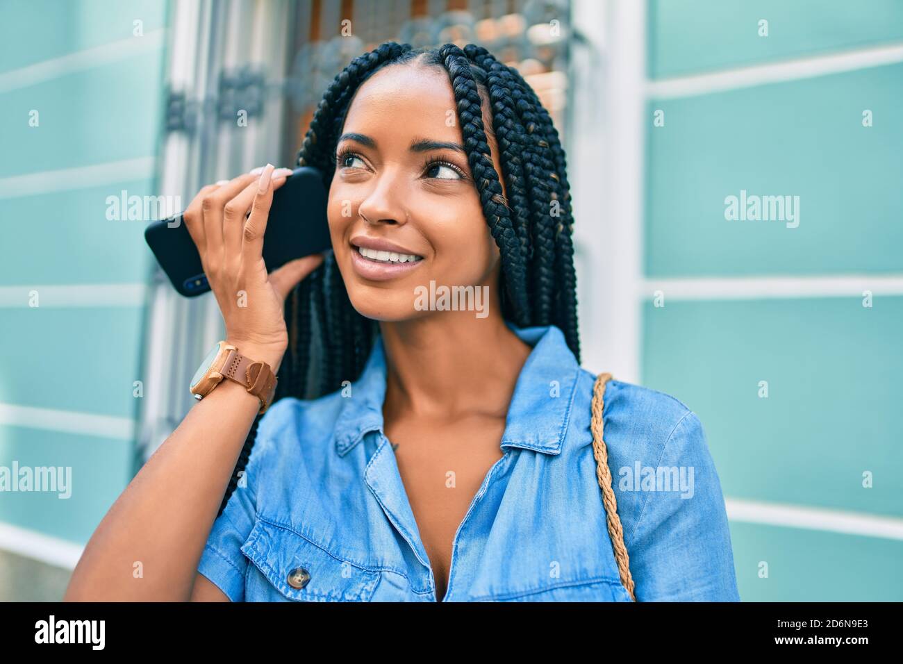 Jeune afro-américaine souriante bonne écoute de message audio à l'aide ...