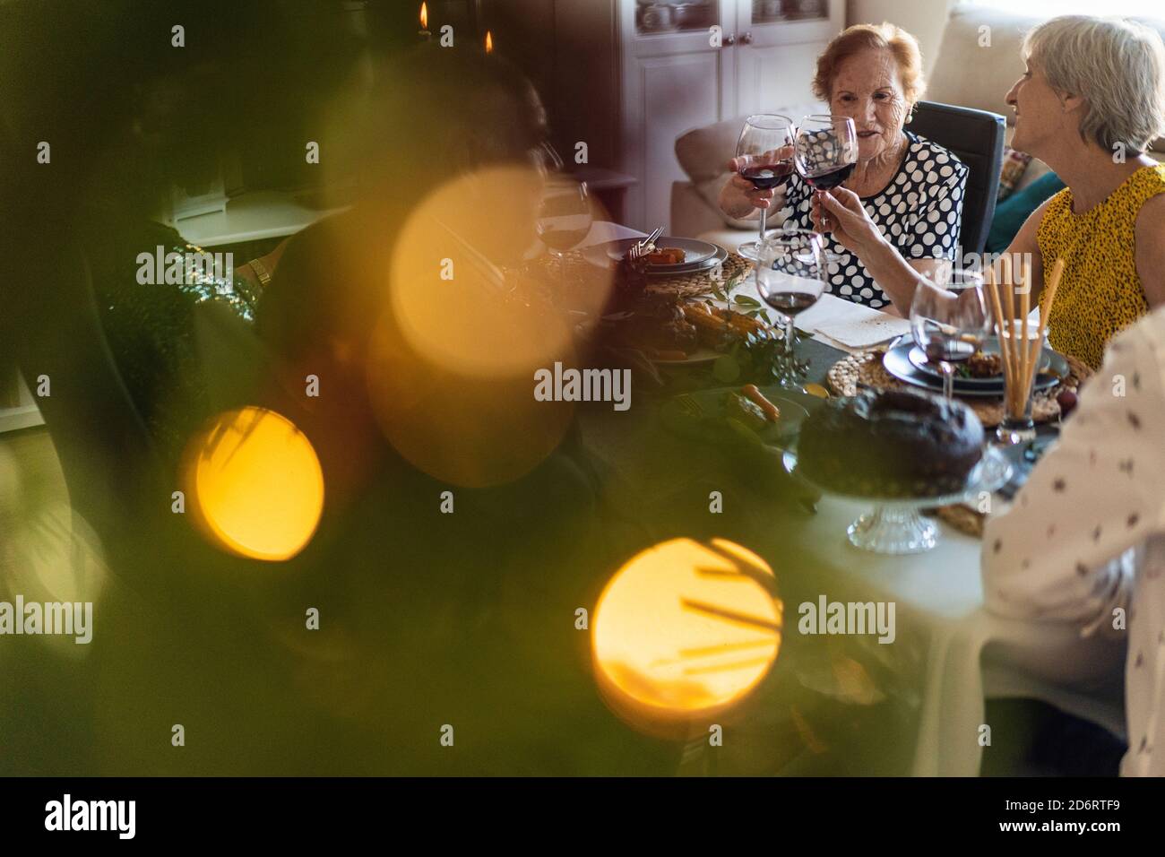 Des amis matures heureux se réunissent à table de fête près d'un Noël ...
