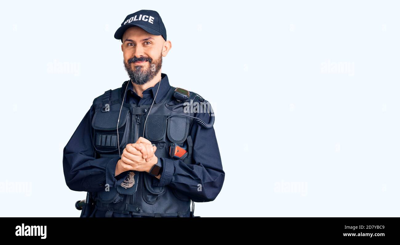 Jeune homme beau portant l'uniforme de police avec les mains ensemble ...